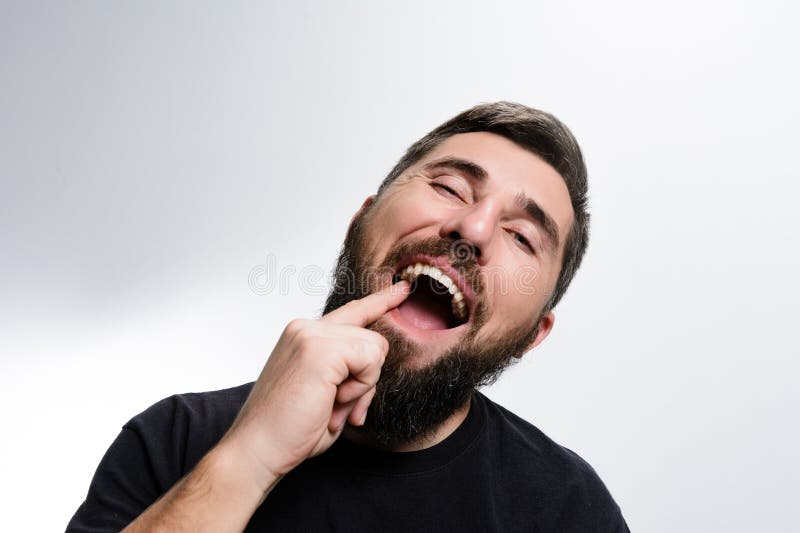Man Pointing at His Teeth and Smiling Widely Against a White Background ...