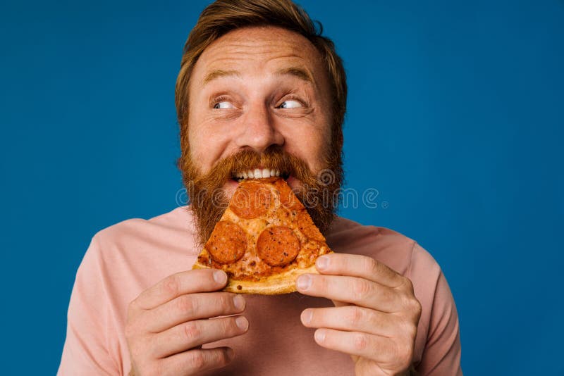 Bearded Man Eating Pizza while Standing Isolated Over Blue Background ...
