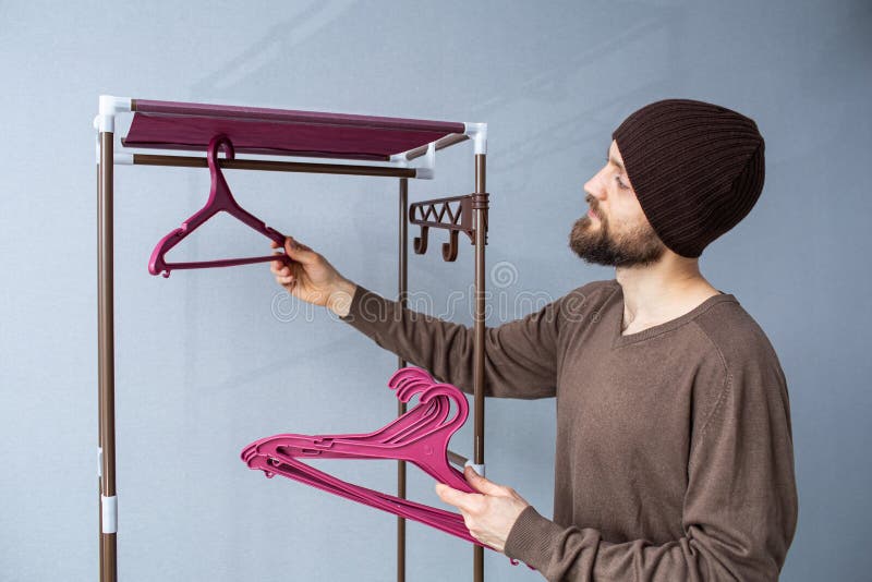 A Bearded Man Hangs Hangers on a Hanger Rack. Stock Image - Image of ...
