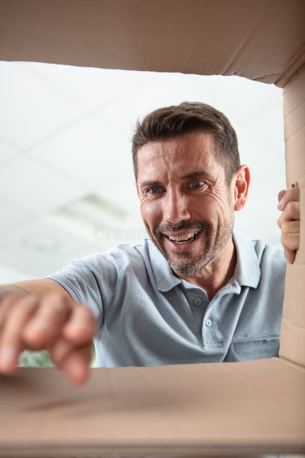 Bearded Man Looking and Reaching into Cardboard Box Stock Photo - Image ...