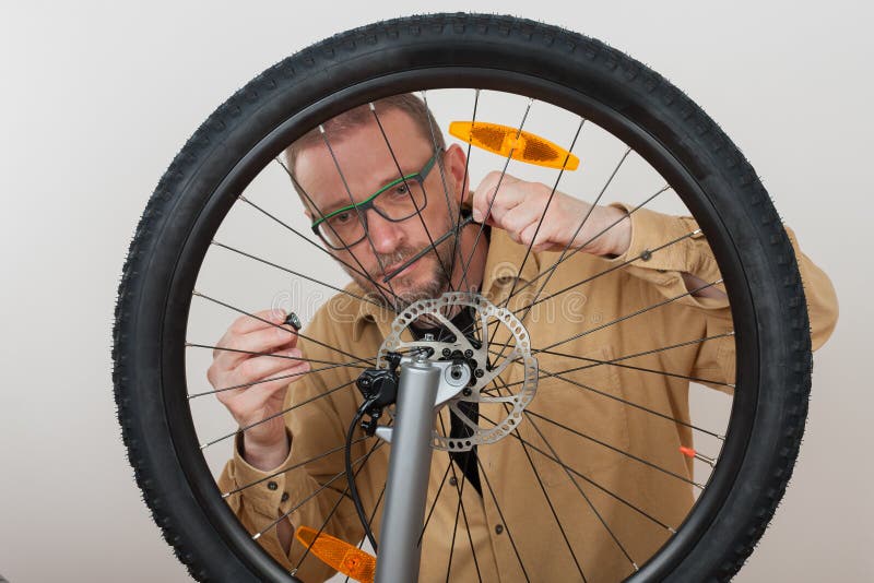 Bearded Man Screws the Front Wheel on the Mtb Bicycle. Stock Photo ...