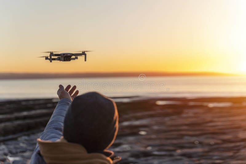 Man Using a Drone with Remote Controller Making Photos and Videos ...