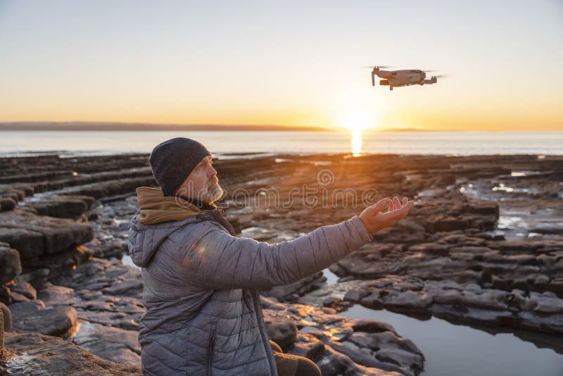 Man Using Drone with Remote Controller Making Photos and Videos, Having ...