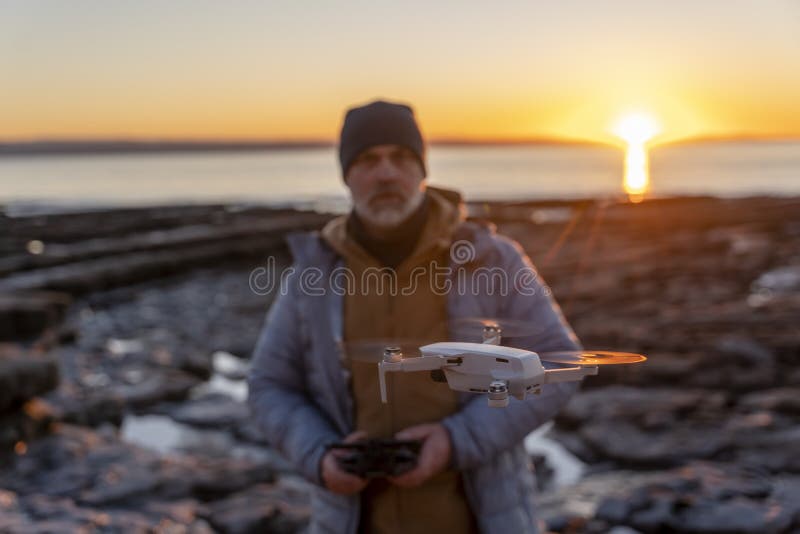 Man Using Drone with Remote Controller Making Photos and Videos, Having ...