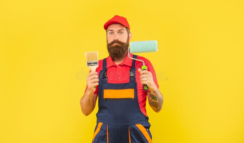 Bearded Puzzled Man Painter in Work Clothes Hold Paint Roller and Brush ...
