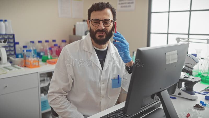 A Bearded Scientist in a Lab Coat Analyzes Data on a Computer while ...