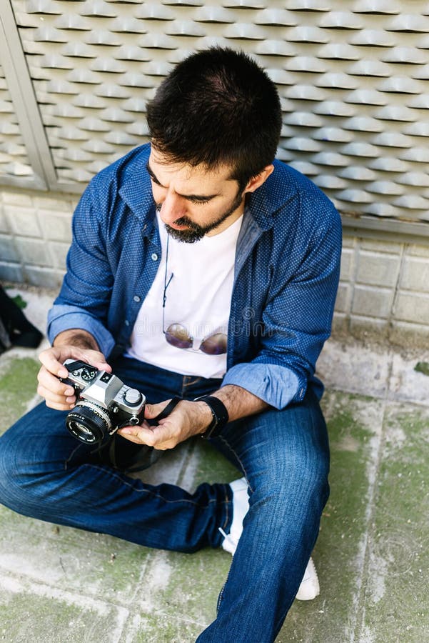 Bearded Traveler Man Sitting on Ground while Using Checking a Camera ...