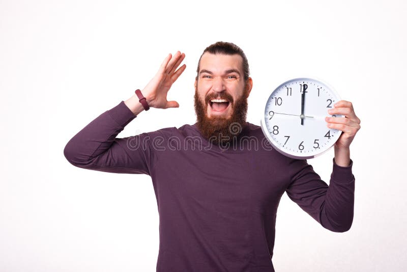 A Bearded Young Man is Being Stressed Holding a Big White Clock Near a ...