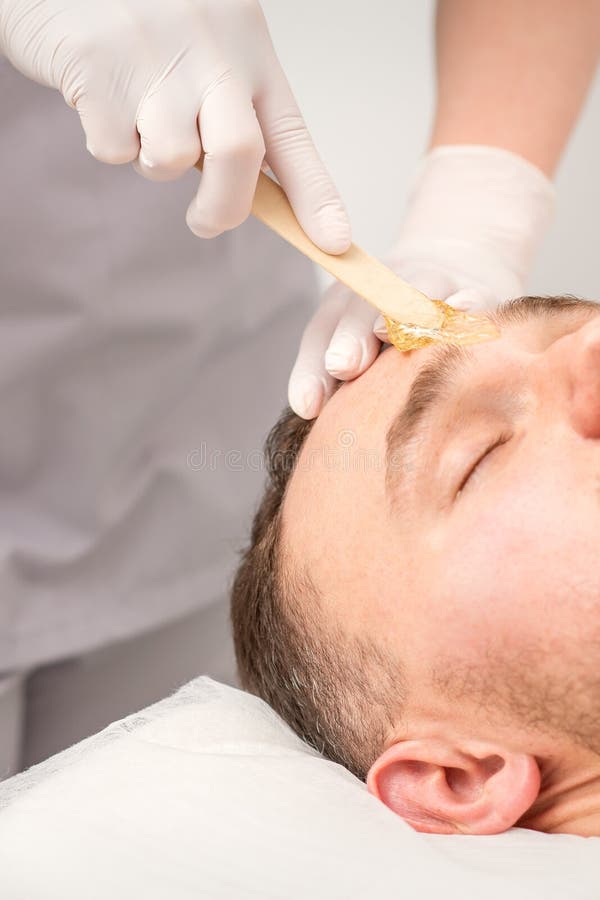 Beautician Applying Wax Paste between Eyebrows during the Procedure of ...