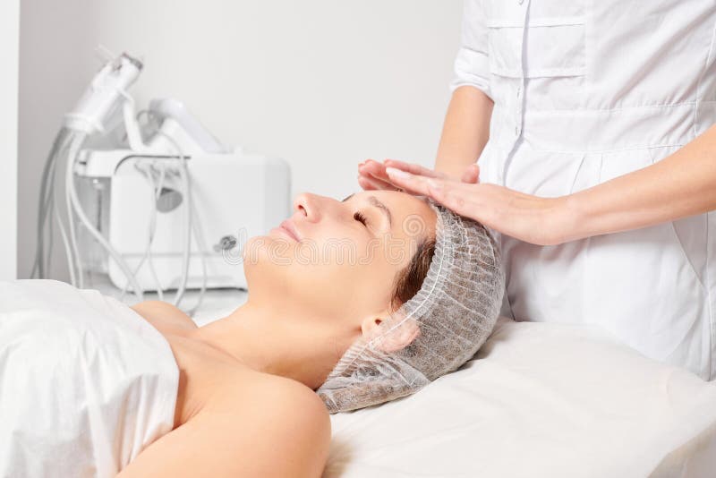 Beautician Rubbing Moisturizing Cream Mask Into Woman Face Skin For