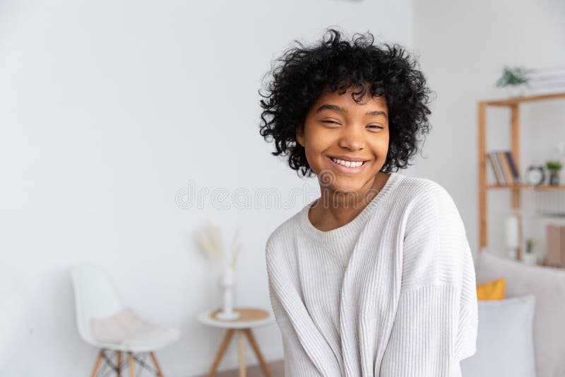 Beautiful African American Girl With Afro Hairstyle Smiling At Home