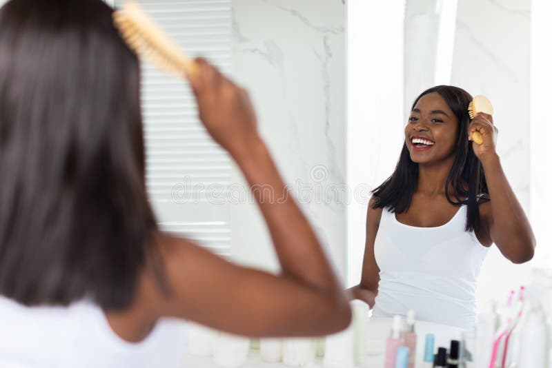 Beautiful African American Woman Combing Her Hair with Bamboo Brush in ... Beautiful African American Woman Combing Her Hair with Bamboo Brush in ...