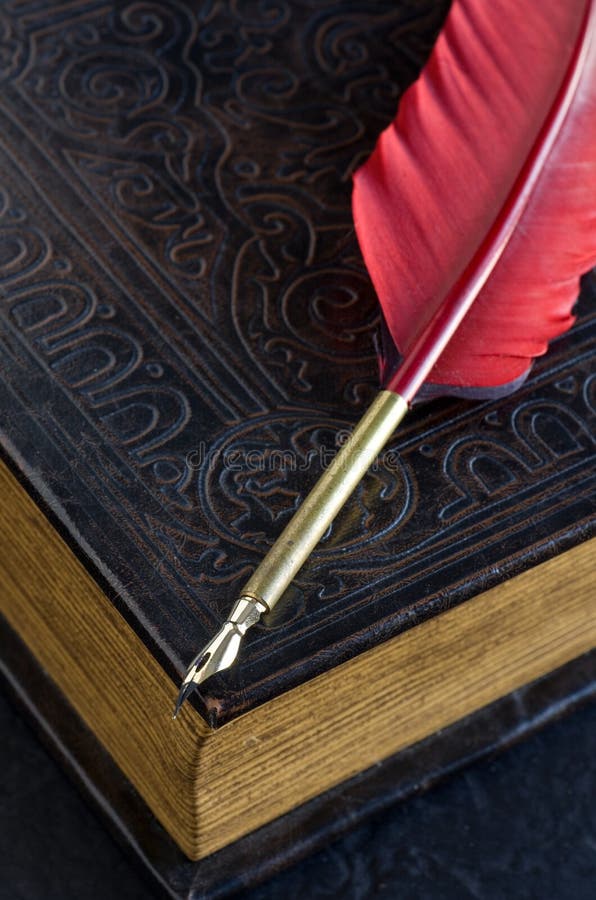 Beautiful Antique Red Feather Pen with Brown Book on Black Table Stock ...