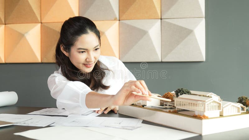 Beautiful Architect Measuring House Model while Taking a Note ...