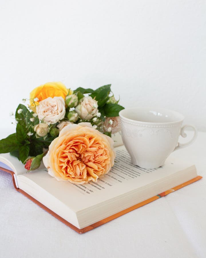 A Beautiful Arrangement of a Bouquet of Roses and a Book Stock Photo ...