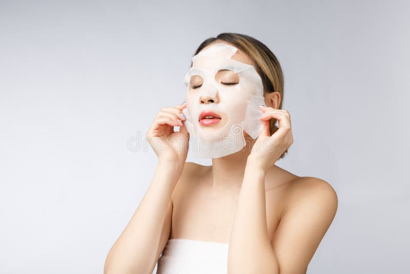 Beautiful Asian Woman Applying Paper Sheet Mask On Her Face White