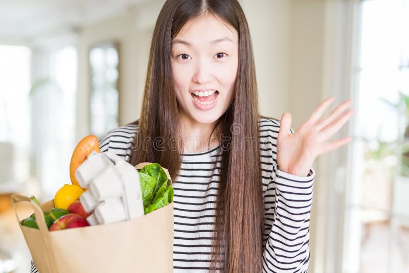 Beautiful Asian Woman Holding Paper Bag Of Fresh Groceries Very Happy