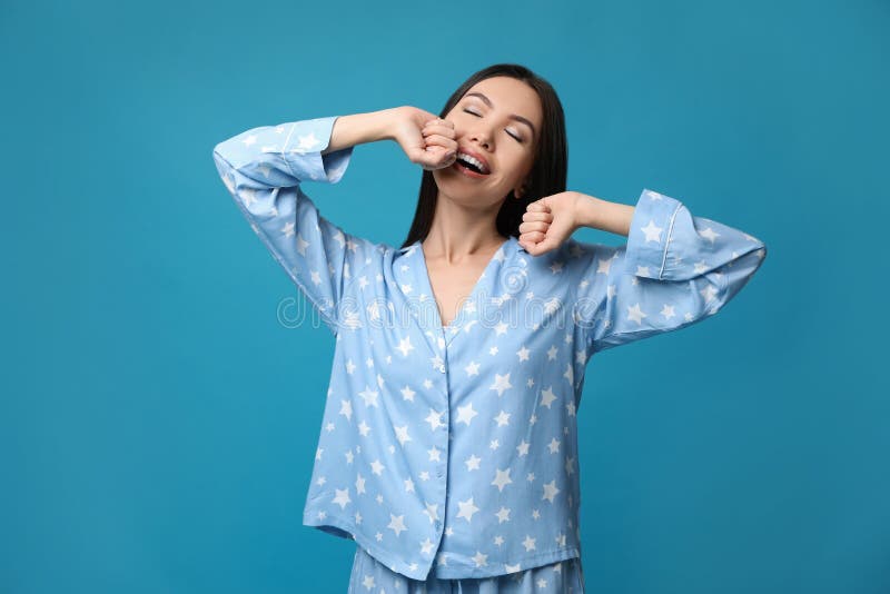 Beautiful Asian Woman In Pajamas Stretching On Background Bedtime