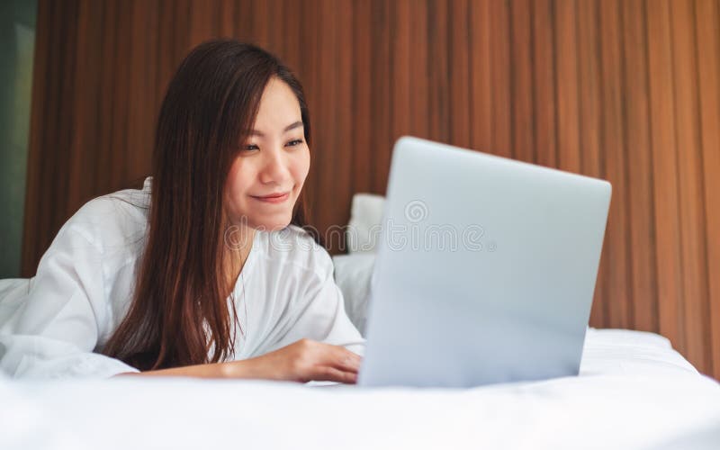 A Beautiful Woman Using and Working on Laptop Computer while Lying Down ...