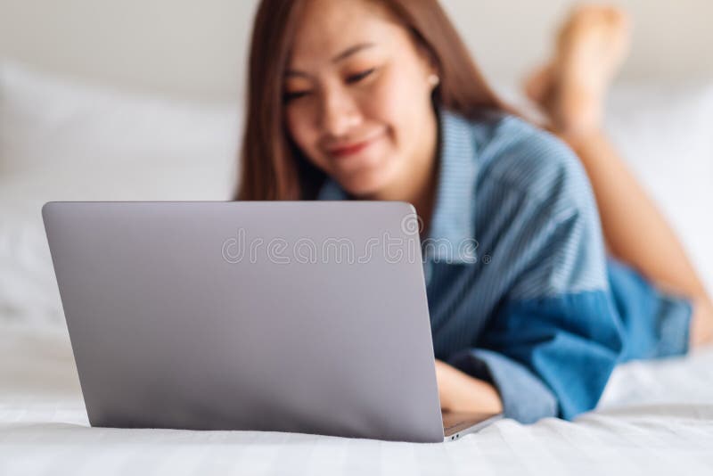 A Beautiful Woman Using and Working on Laptop Computer while Lying Down ...