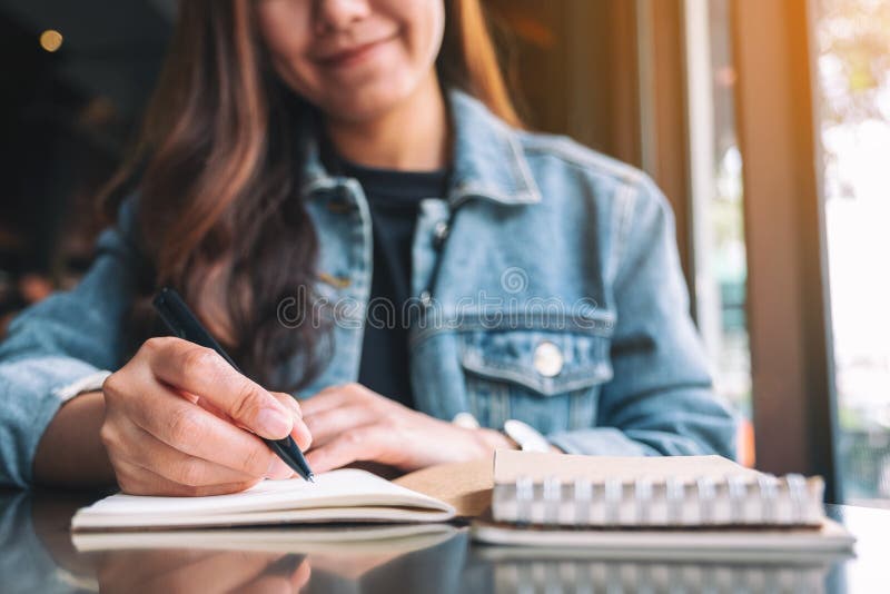 A Beautiful Asian Woman Writing on a Blank Notebook on the Table Stock ...