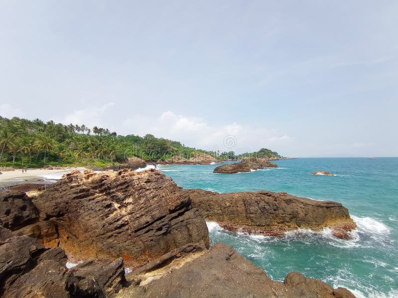 Beautiful Beach during the Day with Stretching Black Coral Rocks Stock ...