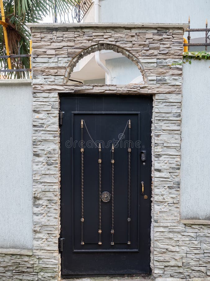 Beautiful Black Gate with Forging Elements in an Arched Stone Opening ...
