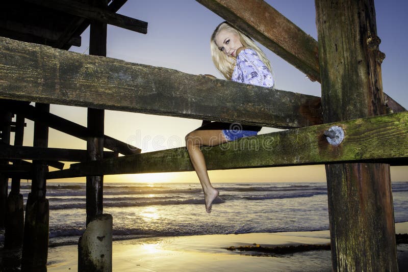 Blond girl under a pier stock image. Image of pacific - 115962945