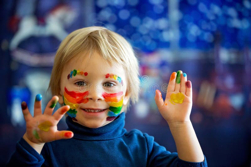 Beautiful Blond Toddler Boy with Rainbow Painted on His Face and Messy ... Beautiful Blond Toddler Boy with Rainbow Painted on His Face and Messy ...