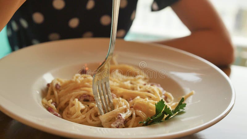 Beautiful Blonde With Glasses Eats Spaghetti Carbonara In A Restaurant