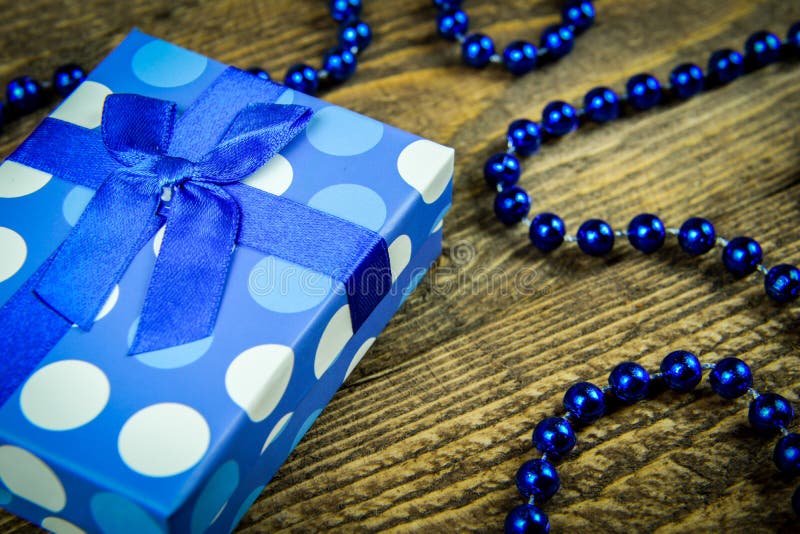 Beautiful Blue a Present with Blue Beads on a Wooden Background Stock ...