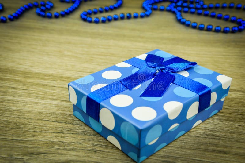 Beautiful Blue a Present with Blue Beads on a Wooden Background Stock ...