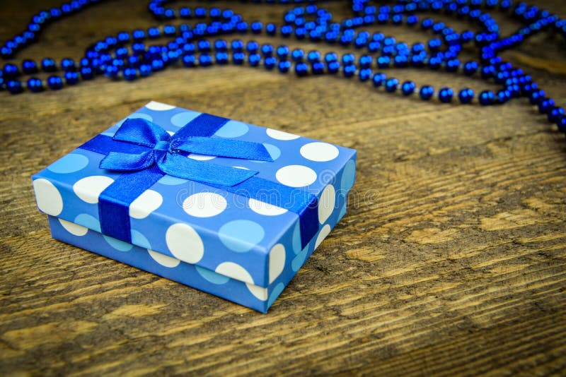 Beautiful Blue a Present with Blue Beads on a Wooden Background Stock ...