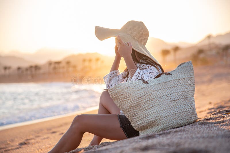 Beautiful Boho Model in a Hat Poses on the Beach in the Sun Stock Photo ...