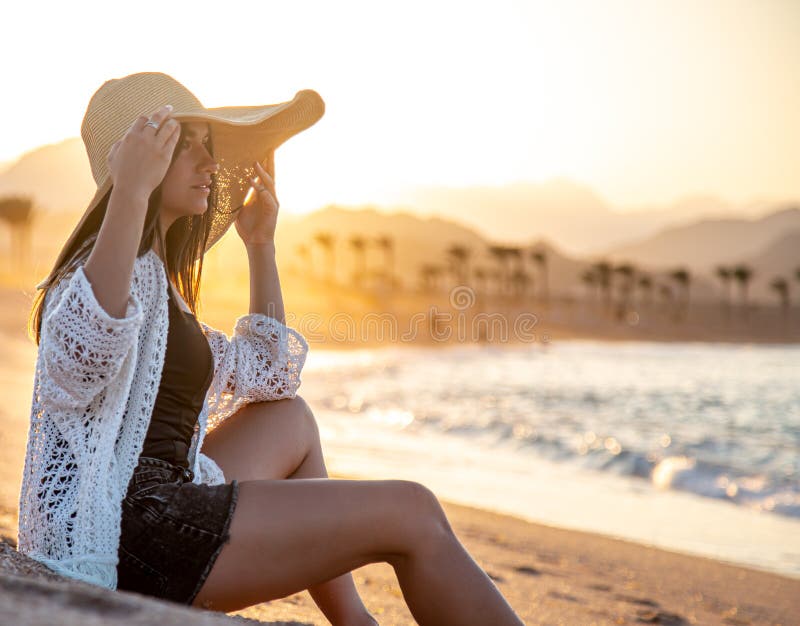 Beautiful Boho Model in a Hat Poses on the Beach in the Sun Stock Image ...