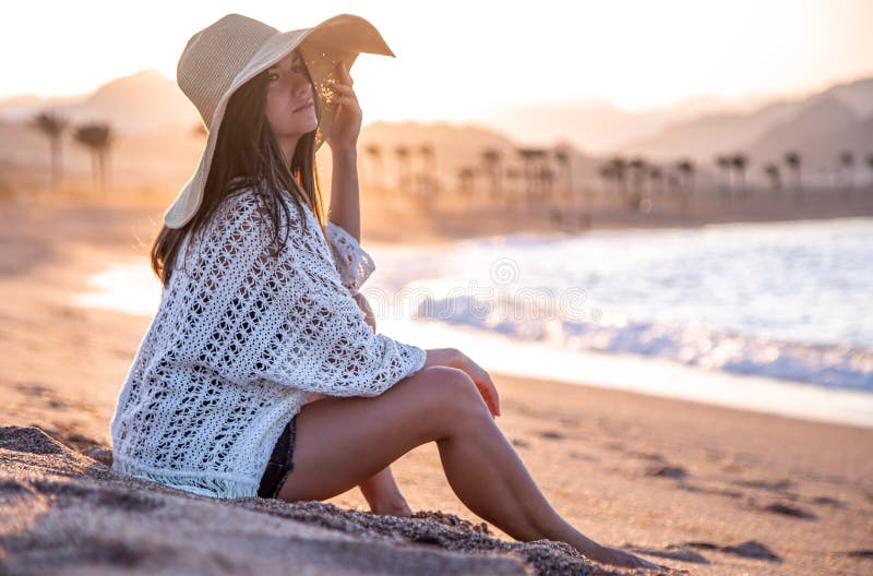 Beautiful Boho Model in a Hat Poses on the Beach in the Sun Stock Image ...