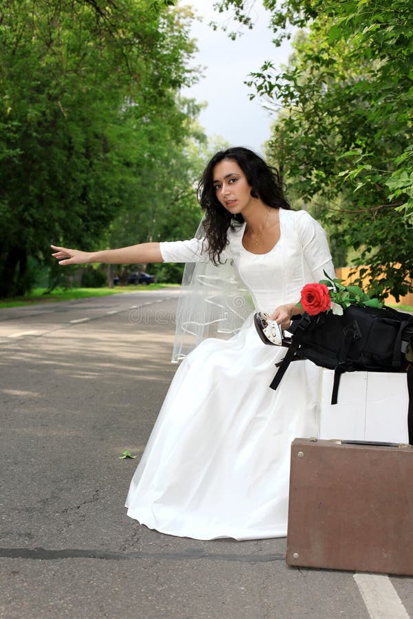Beautiful bride hitch-hike stock photo. Image of road - 11294526