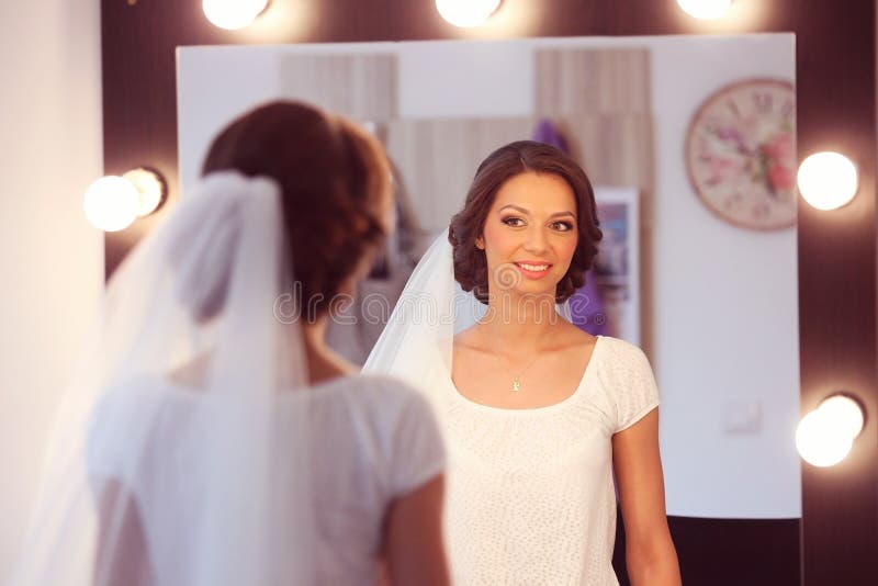 Beautiful Bride Looking at Herself in the Mirror Stock Photo - Image of ...