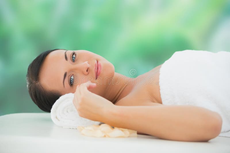 Beautiful Brunette Relaxing On Massage Table Smiling At Camera Stock