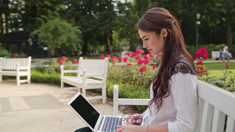 Lady Sitting on Bench in the Park and Using Laptop Stock Photo - Image ...