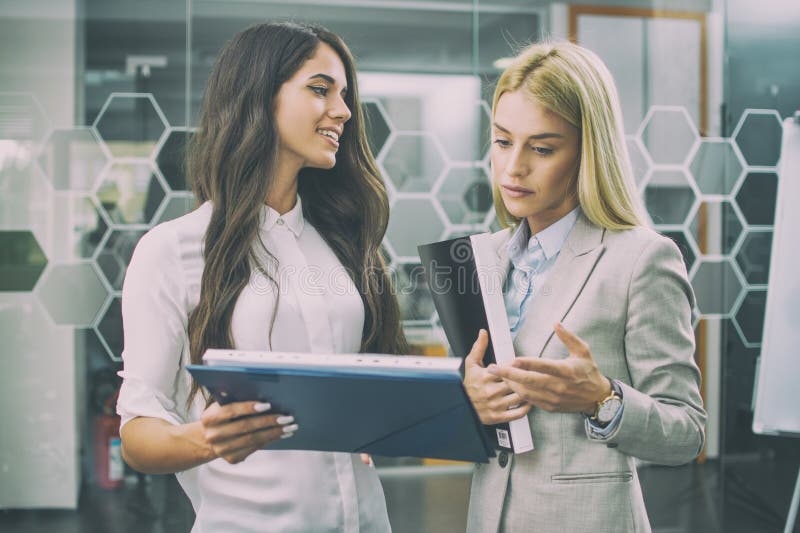 Beautiful Business Women Discussing Document during a Meeting in Office ...