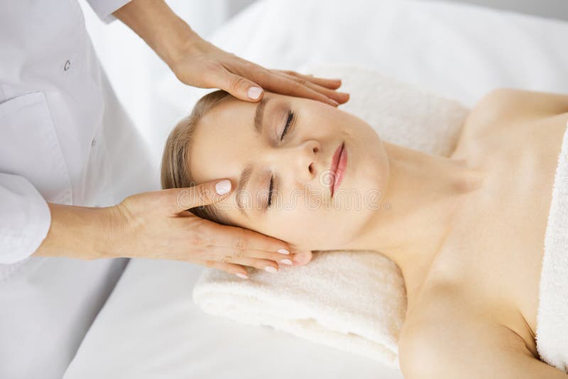 Beautiful Caucasian Woman Enjoying Facial Massage With Closed Eyes In