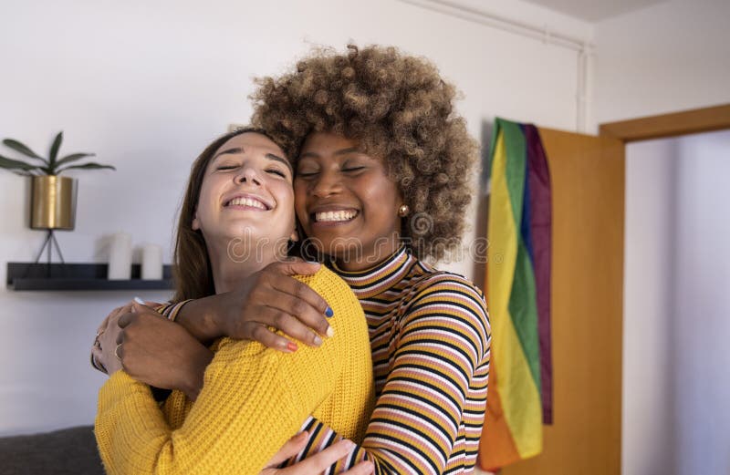 Beautiful And Cheerful Multiracial Lesbian Couple Hugging And Looking