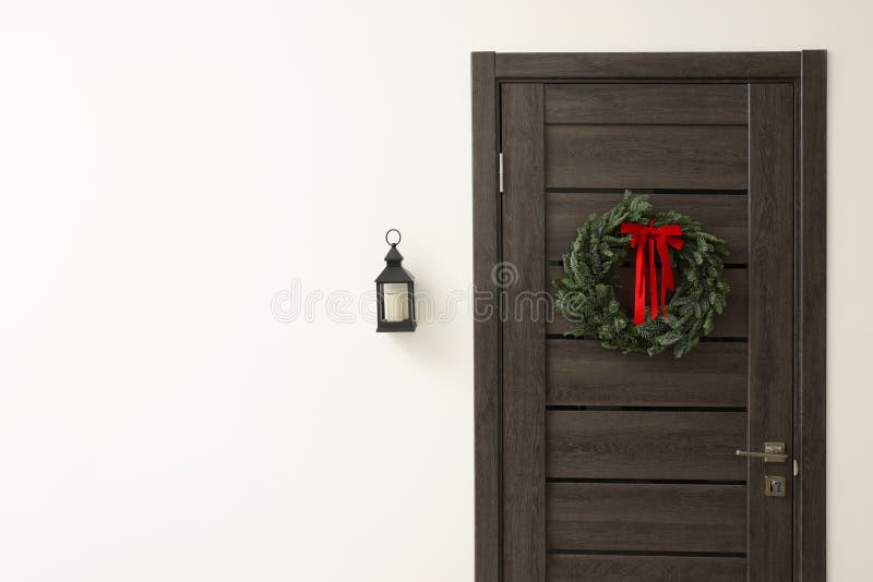 Beautiful Christmas Wreath with Red Bow Hanging on Door. Space for Text ...
