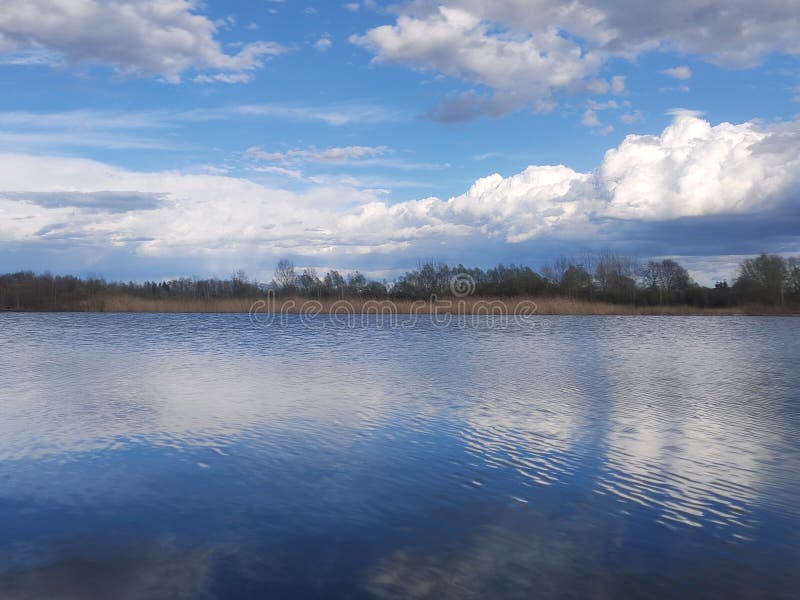 Beautiful Cloudy Sky Mirroring in the Lake Water on a Windy Spring Day ...