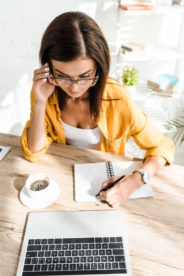 Confident Freelancer with Coffee Cup Working with Laptop and Notebook ...