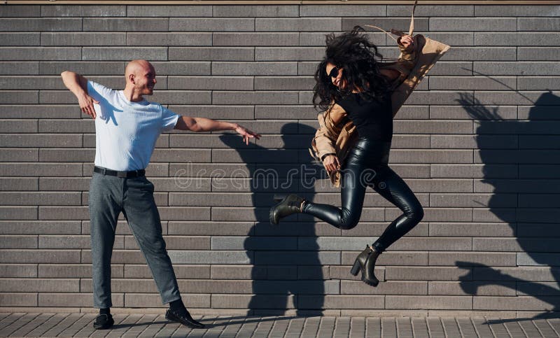Beautiful Couple in Black Clothes Dancing Together Against Wall ...