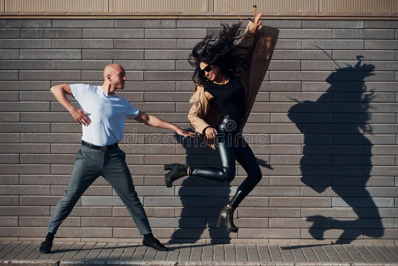 Beautiful Couple in Black Clothes Dancing Together Against Wall ...