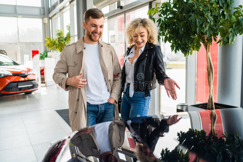 Beautiful Couple in Car Dealership Chooses Car. Stock Photo - Image of ...