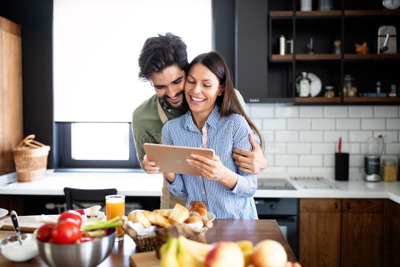 Beautiful Couple in the Kitchen while Cooking. Stock Photo - Image of ...
